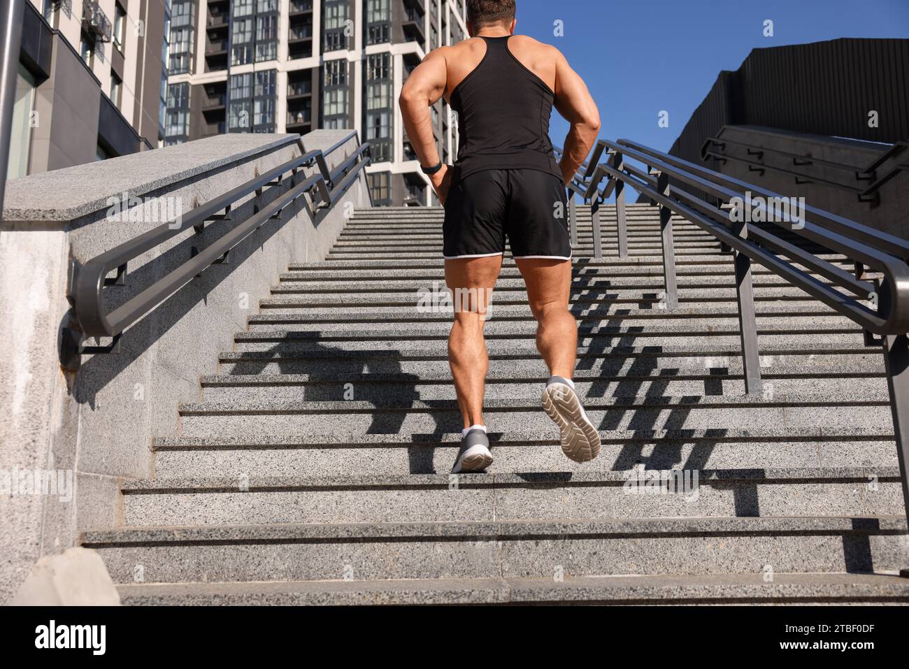 Man running up stairs outdoors on sunny day, back view Stock Photo - Alamy