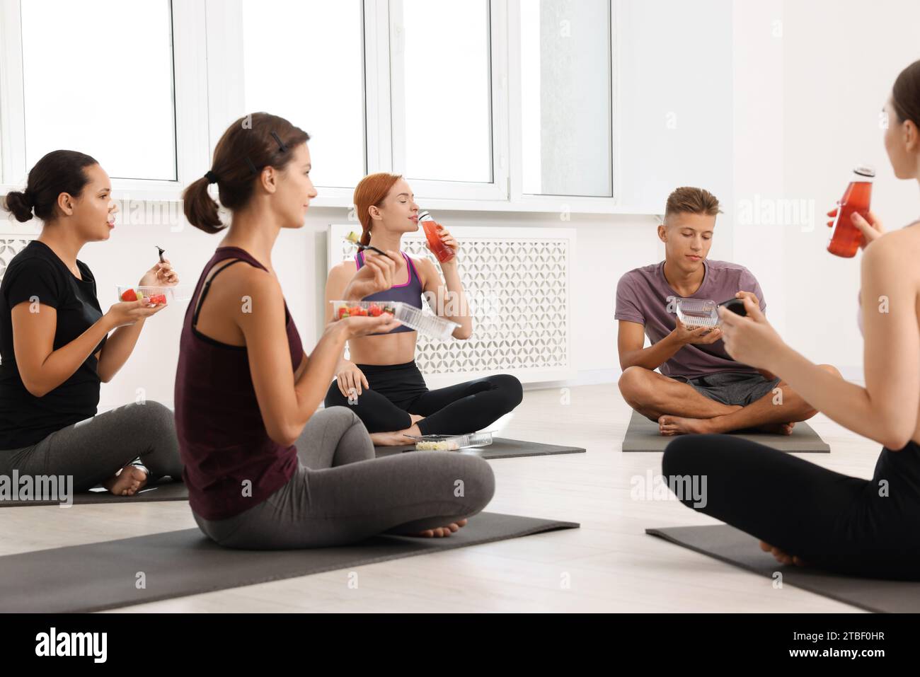 Group of people eating healthy food after yoga class indoors Stock ...