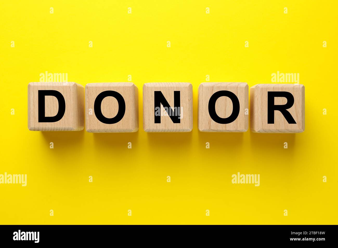 Wooden cubes with word Donor on yellow background, flay lay Stock Photo ...