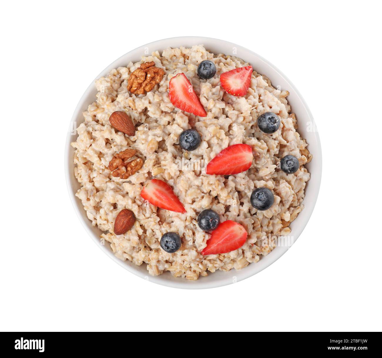 Tasty boiled oatmeal with berries and nuts in bowl isolated on white ...