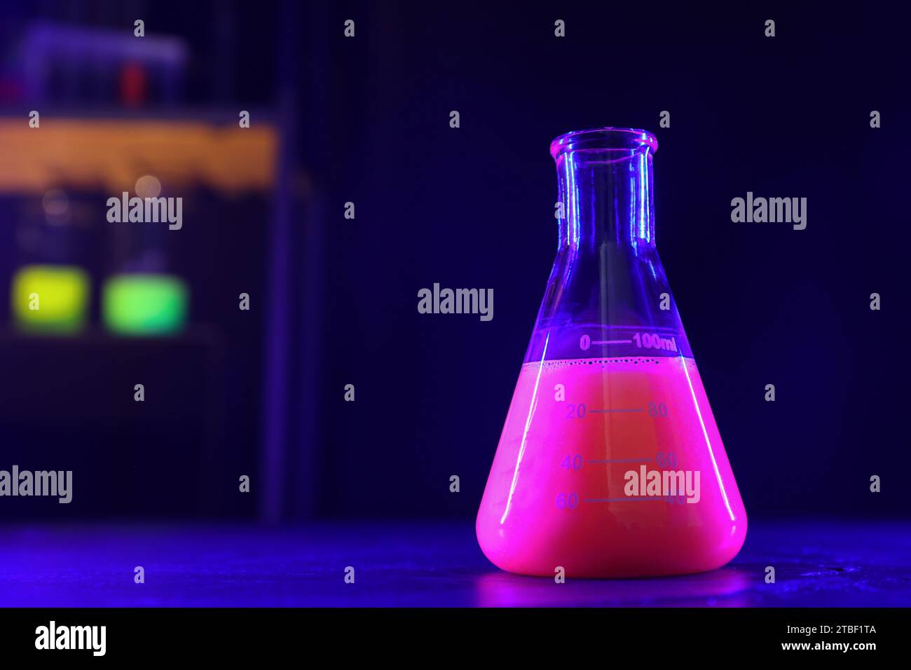 Flask with luminous liquid on table in laboratory, space for text Stock ...