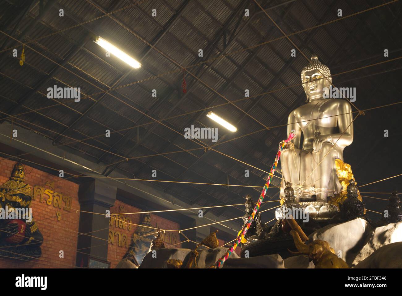 A large silver seated Buddha statue in the Pa Lelai pose. Inside the ...