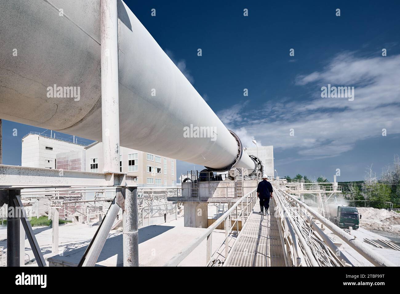 Worker walks along ladders for maintenance of rotary kiln Stock Photo ...