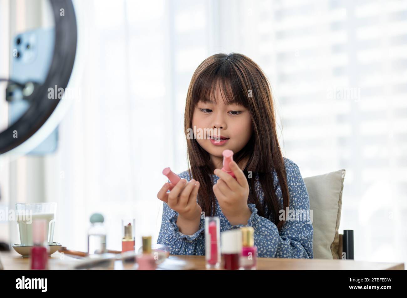A pretty and talented young Asian girl is showing kid cosmetic products ...