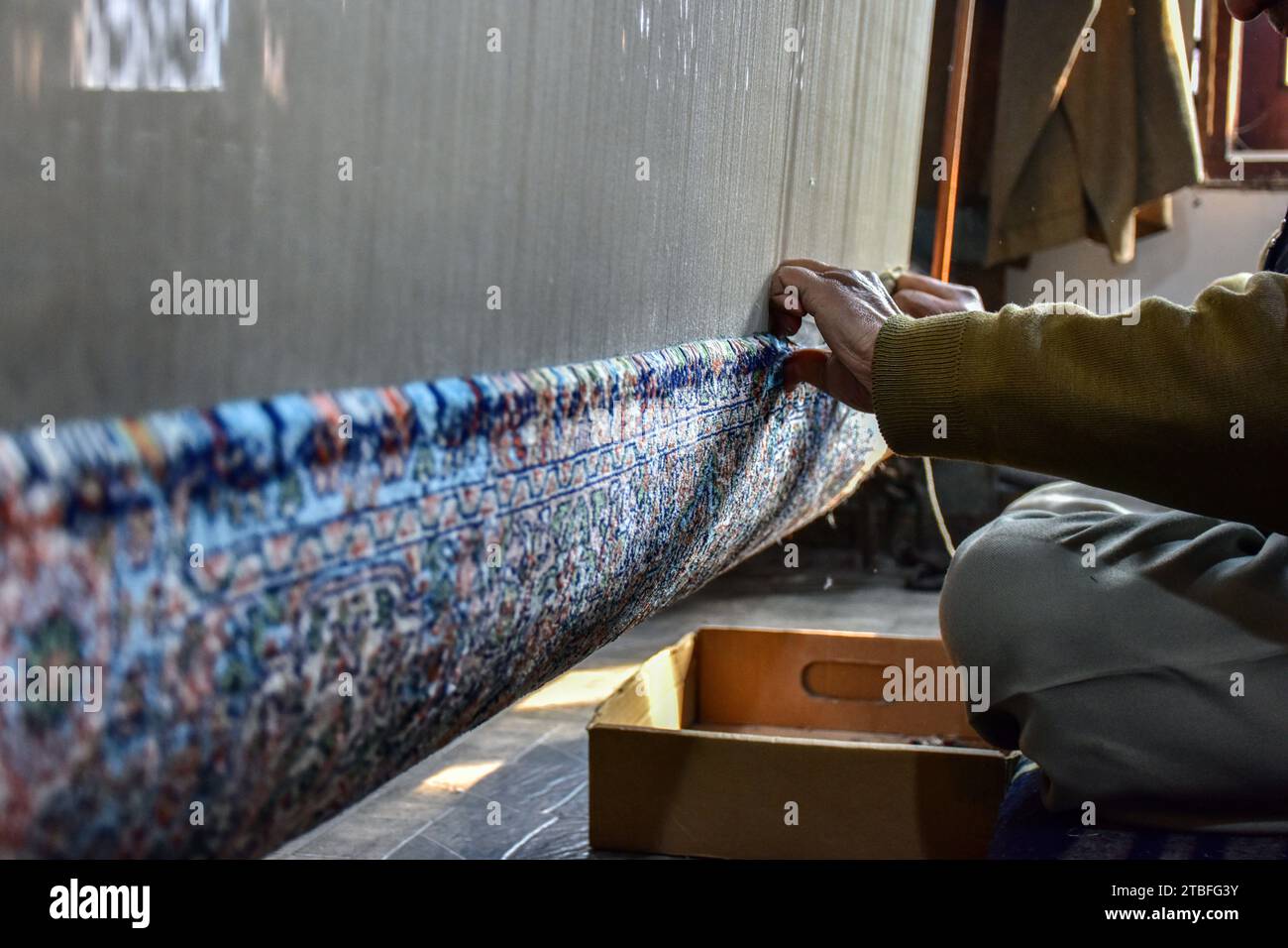 A Kashmiri artisan weaves a traditional carpet at a factory in Srinagar ...