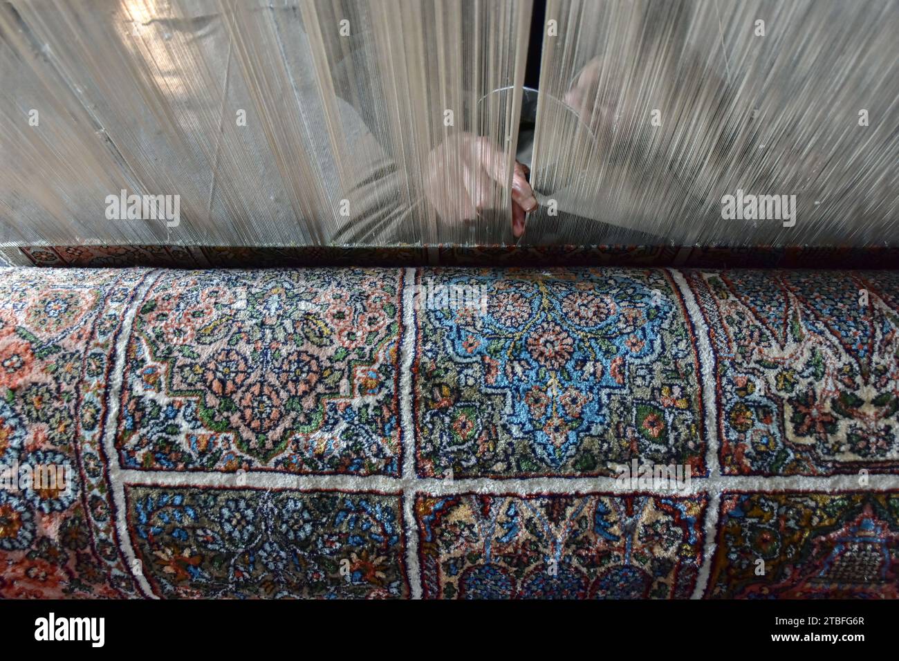 A Kashmiri artisan weaves a traditional carpet at a factory in Srinagar ...
