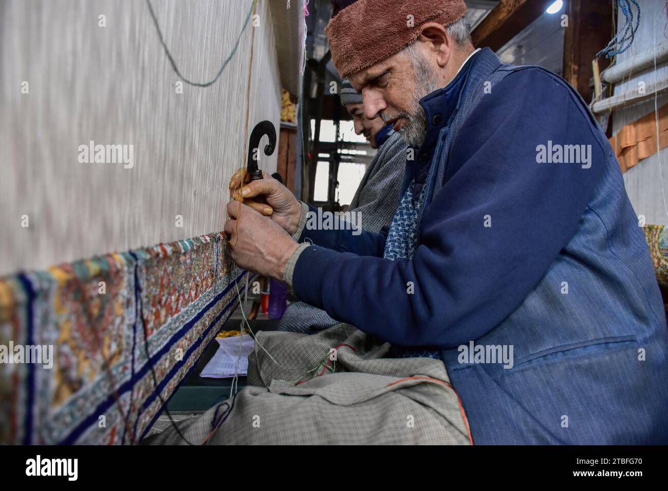 A Kashmiri artisan weaves a traditional carpet at a factory in Srinagar ...