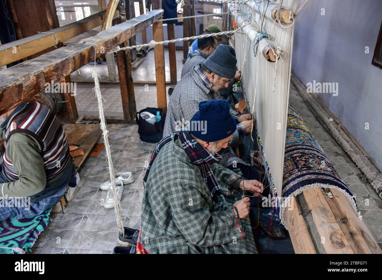 Kashmiri artisans weave a traditional carpet at a factory in Srinagar ...