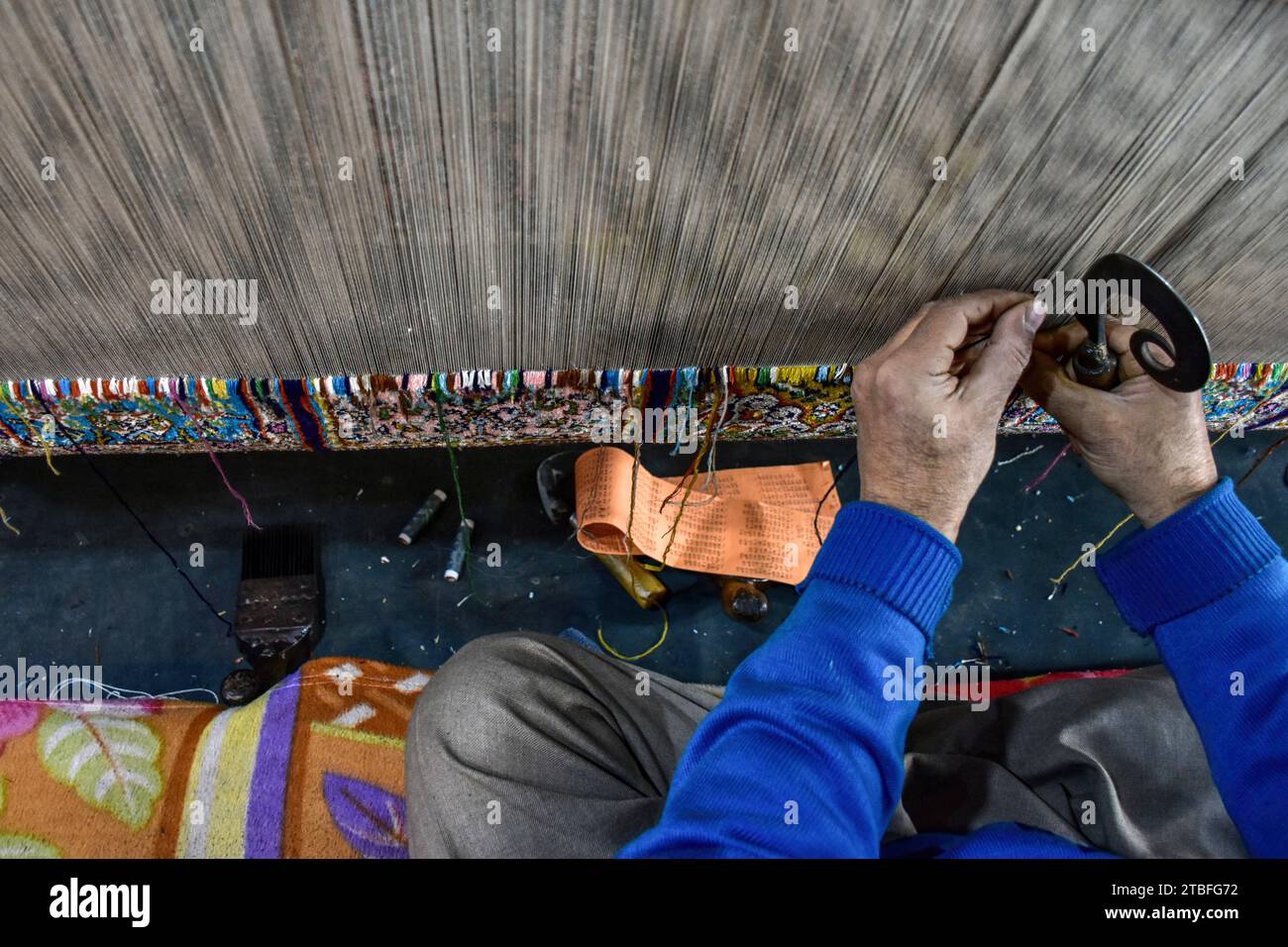 A Kashmiri artisan weaves a traditional carpet at a factory in Srinagar ...