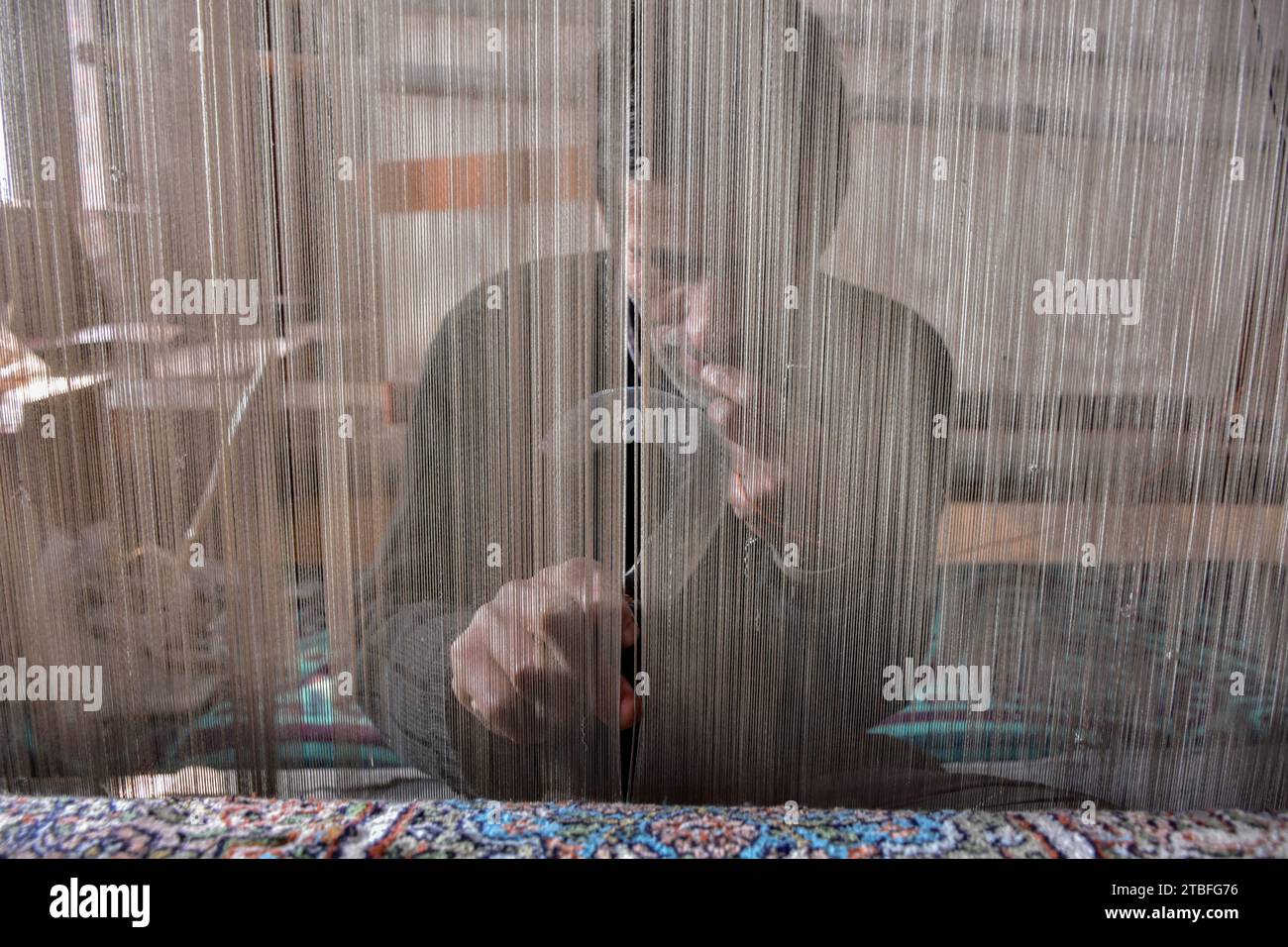 A Kashmiri artisan weaves a traditional carpet at a factory in Srinagar ...