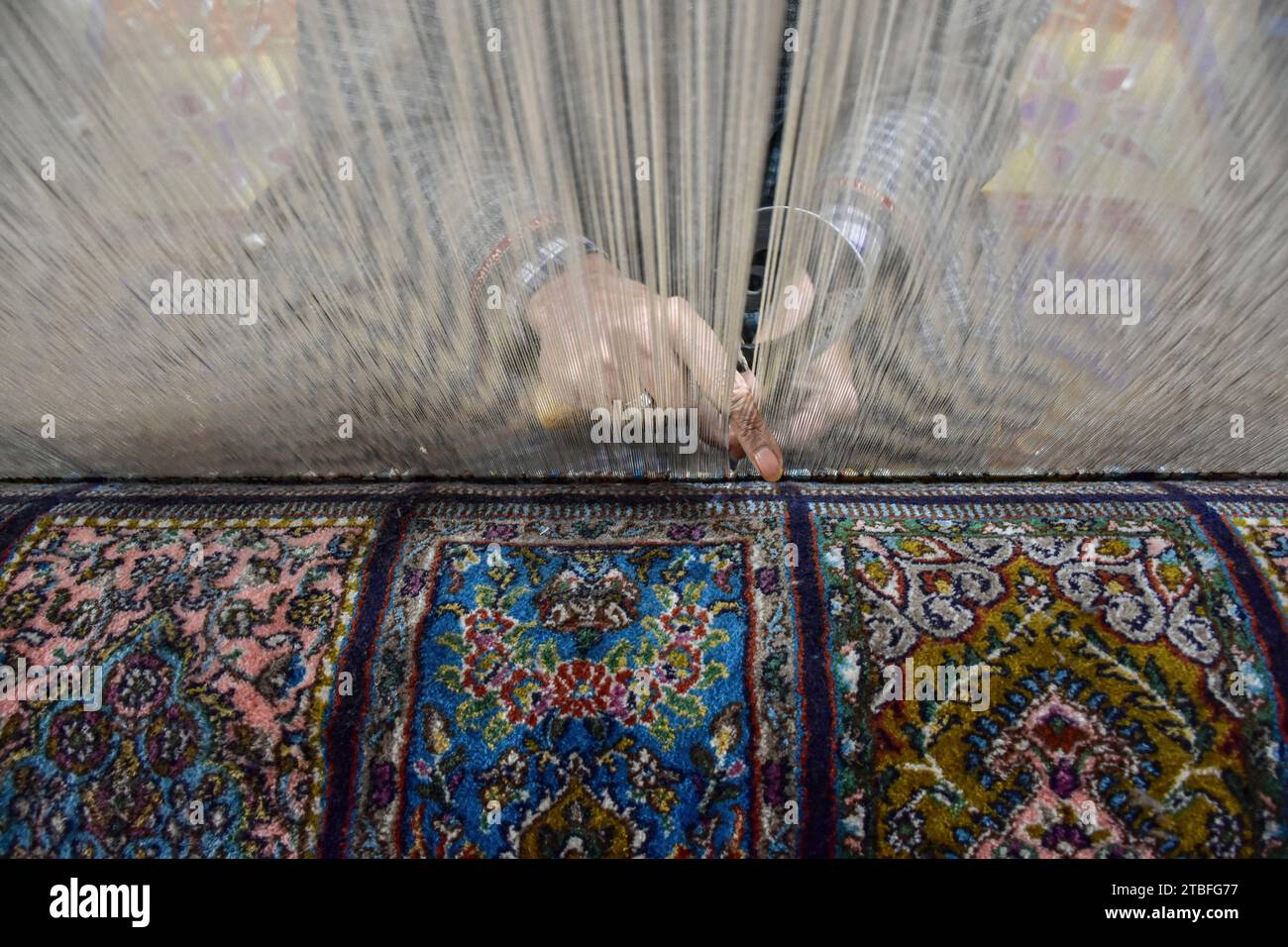 A Kashmiri artisan weaves a traditional carpet at a factory in Srinagar ...