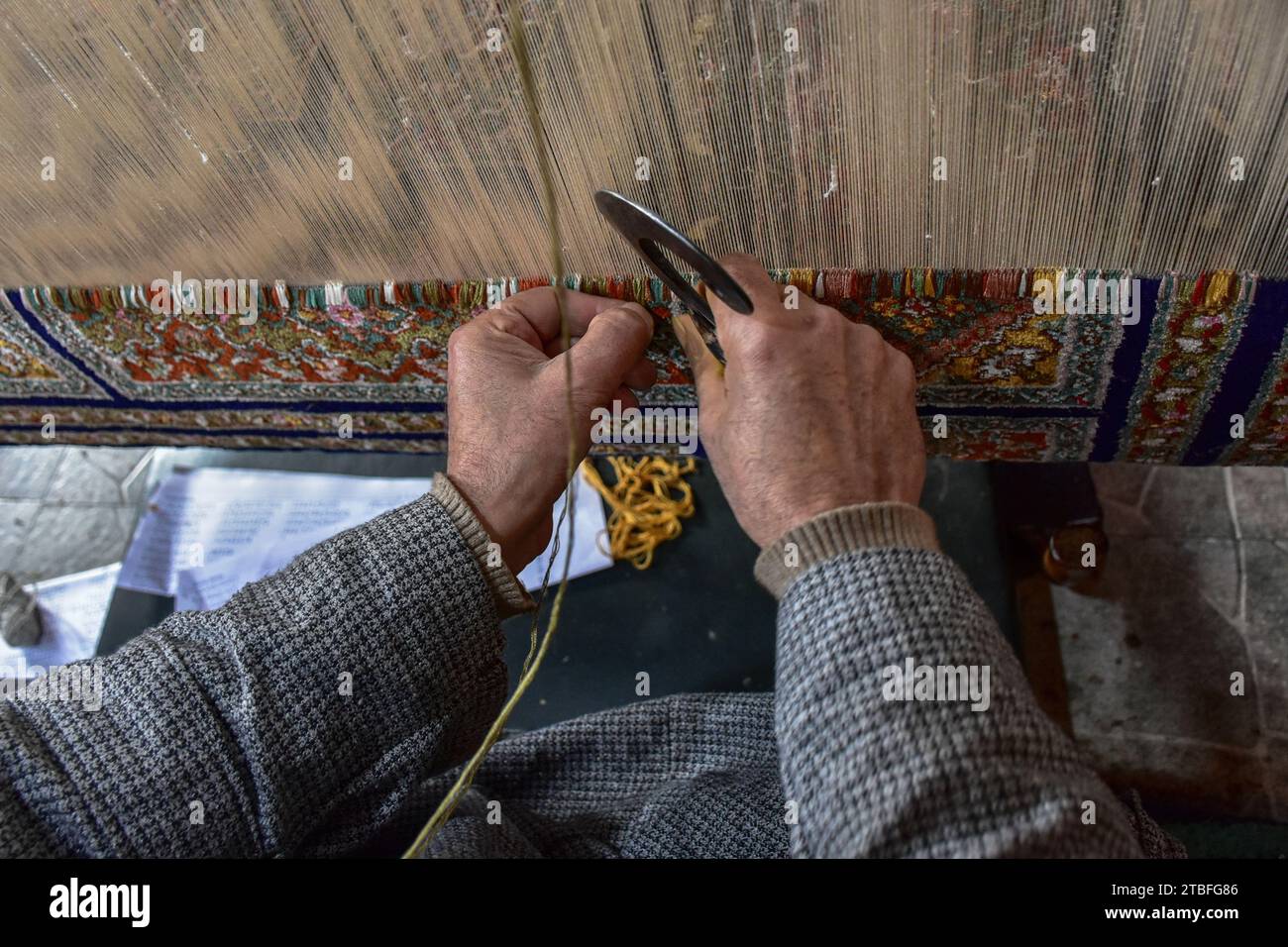 A Kashmiri artisan weaves a traditional carpet at a factory in Srinagar ...