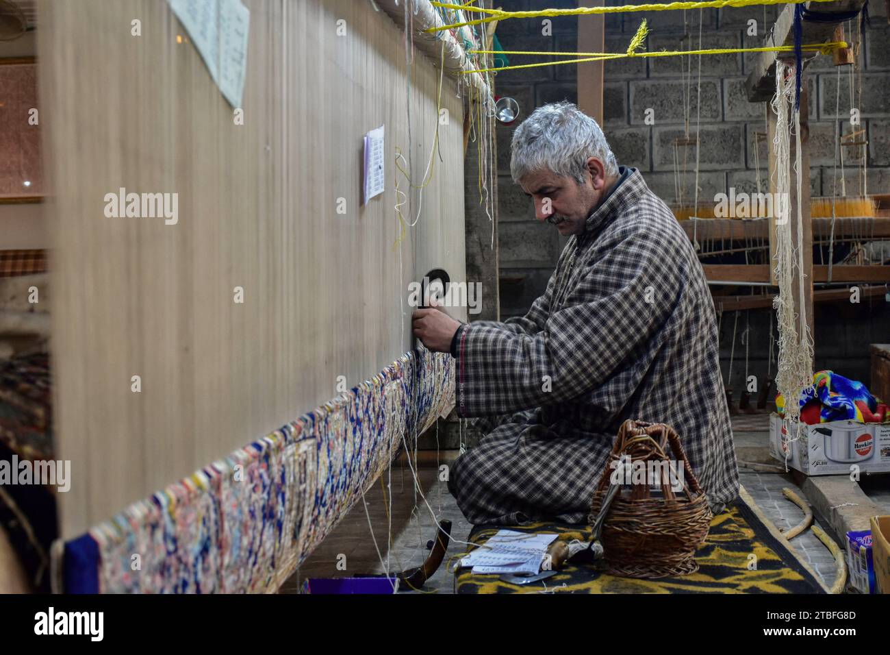 A Kashmiri artisan weaves a traditional carpet at a factory in Srinagar ...