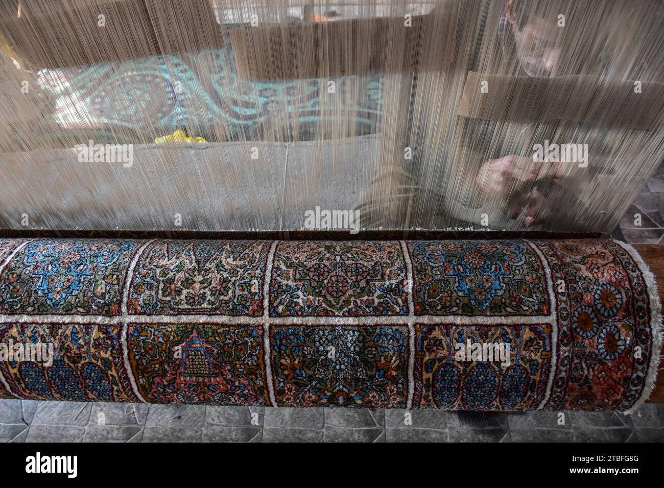 A Kashmiri artisan weaves a traditional carpet at a factory in Srinagar ...