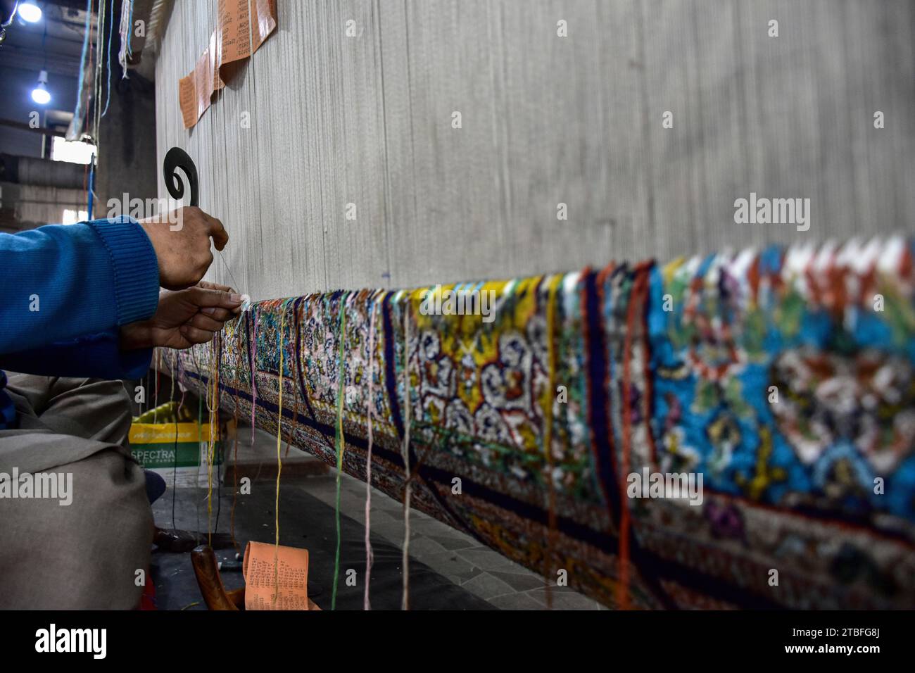 A Kashmiri artisan weaves a traditional carpet at a factory in Srinagar ...