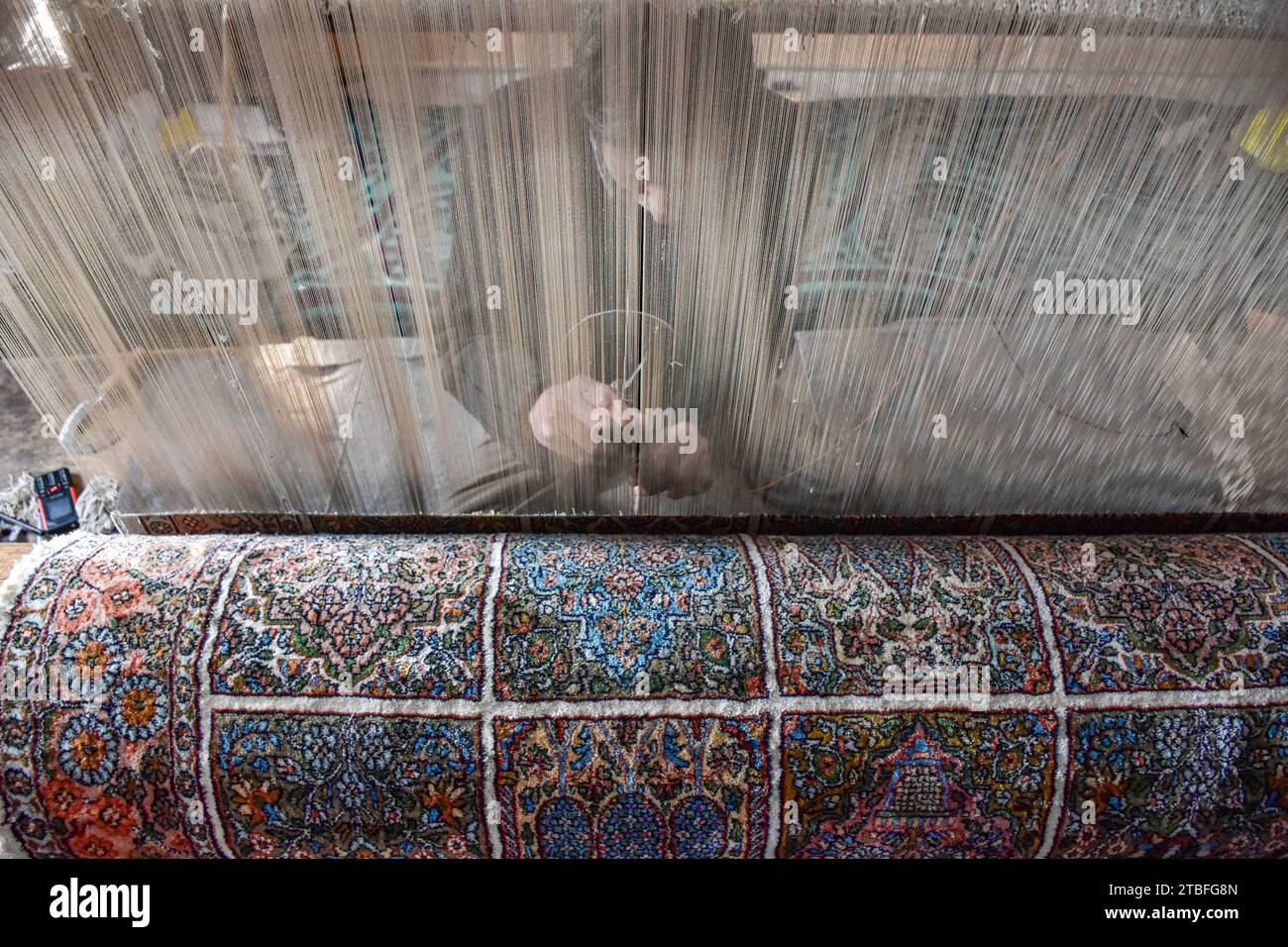 A Kashmiri artisan weaves a traditional carpet at a factory in Srinagar ...