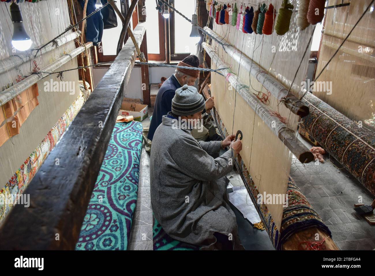 Kashmiri artisans weave a traditional carpet at a factory in Srinagar ...