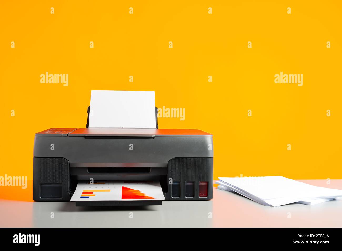 Laser printer on desk against yellow background Stock Photo - Alamy