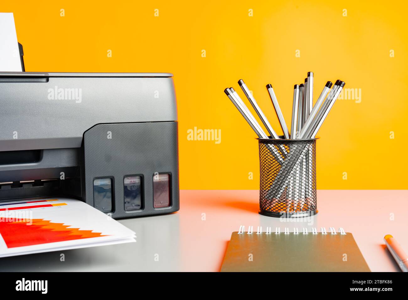 Laser printer on desk against yellow background Stock Photo - Alamy