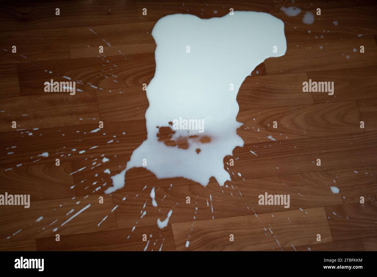 Spilled milk on the floor. White spot of liquid with splashes. Healthy ...