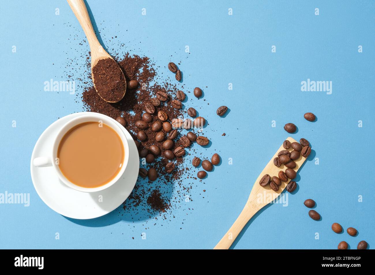 A glass of milky coffee is placed next to coffee beans and coffee ...