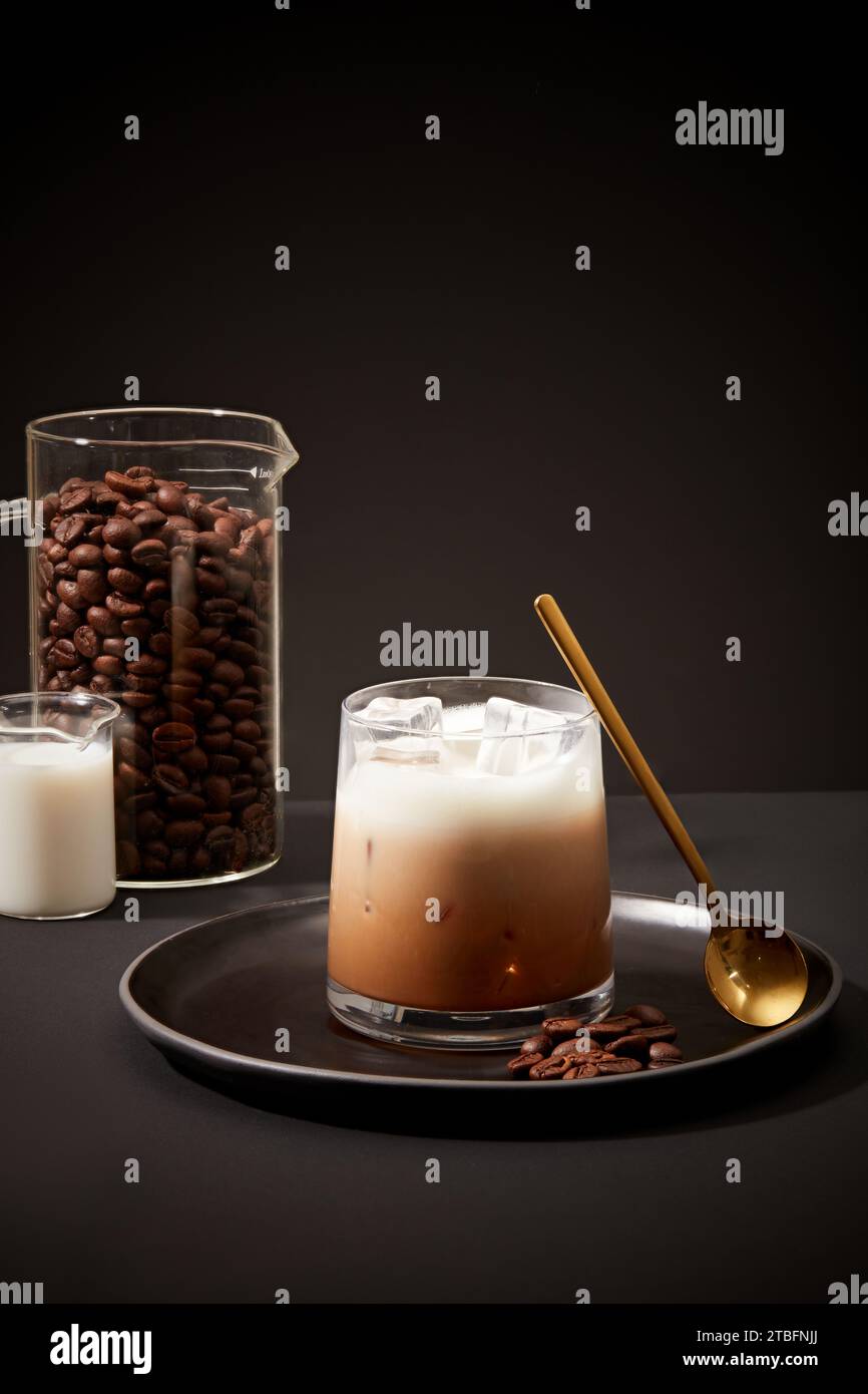 Front view of an iced milk coffee placed on a tray with a metal spoon ...
