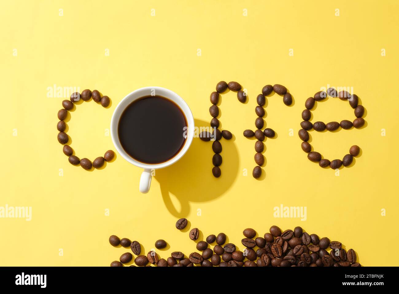 Coffee beans are arranged into the word COFFE with a black coffee cup ...