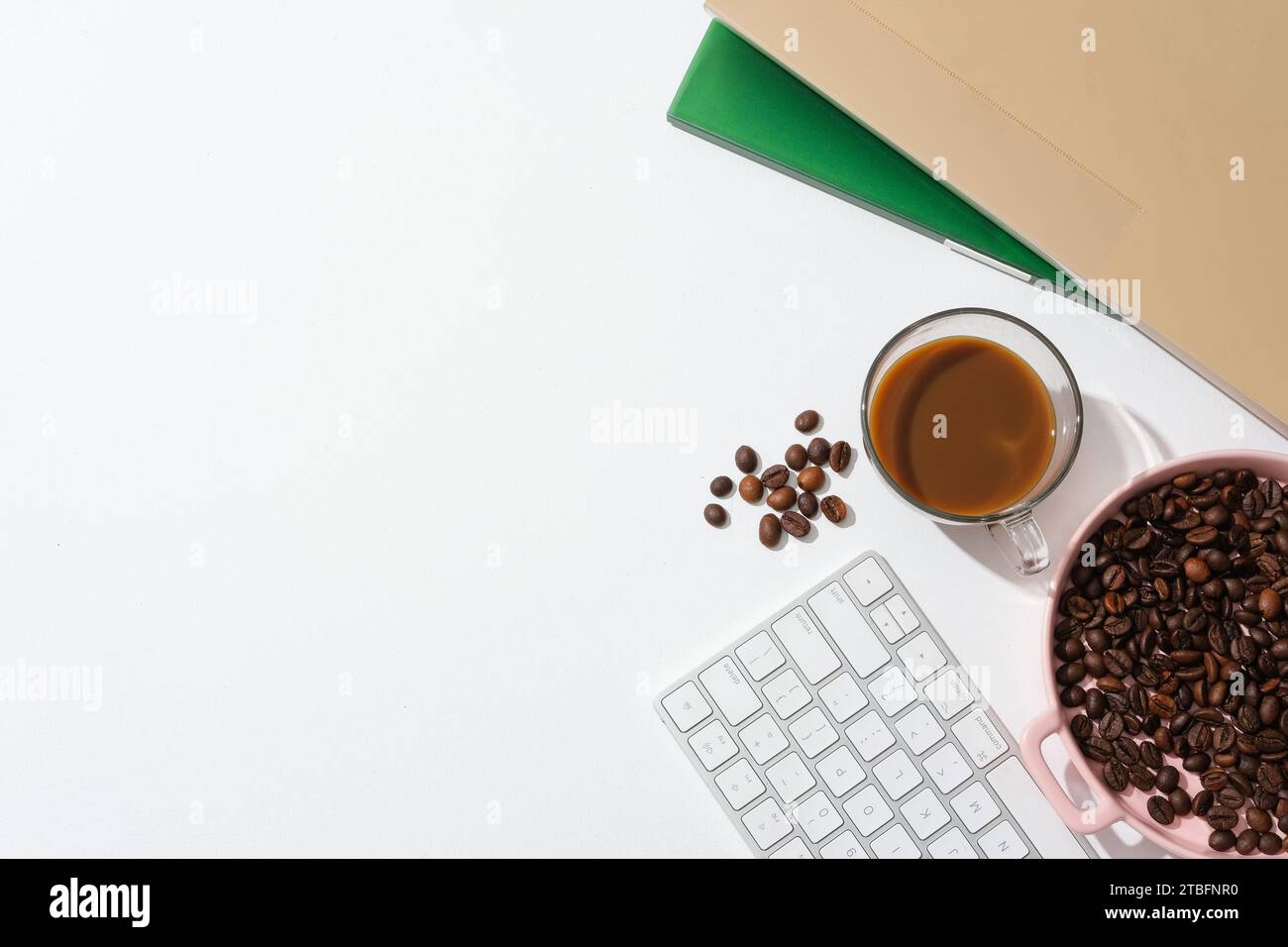 Coffee beans in a pink ceramic tray, a keyboard and a cup of coffee on ...