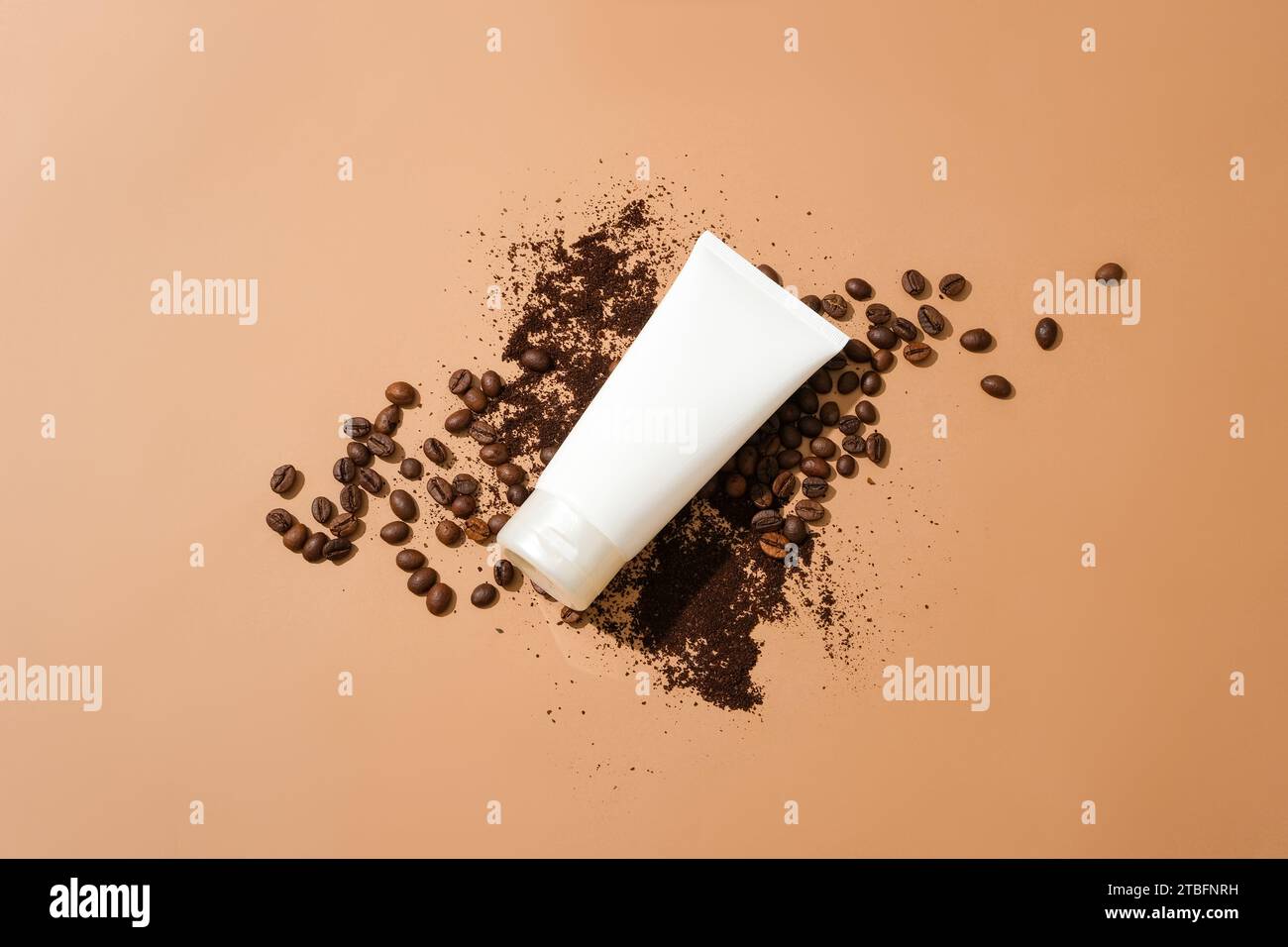 An unlabeled cosmetic tube is placed on top of coffee beans and coffee ...