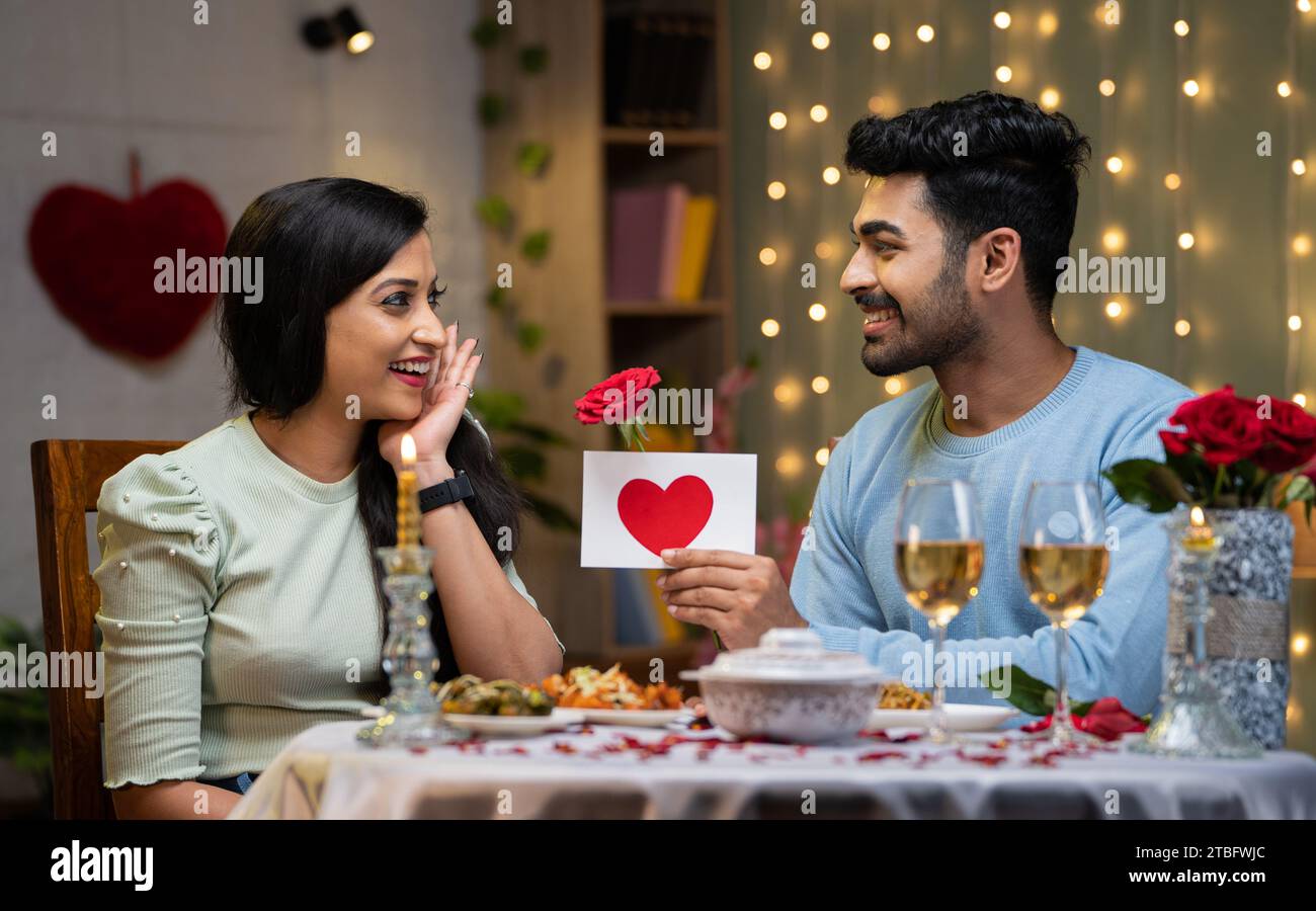 Happy girl excited by boyfriends proposal with red roses during candle ...