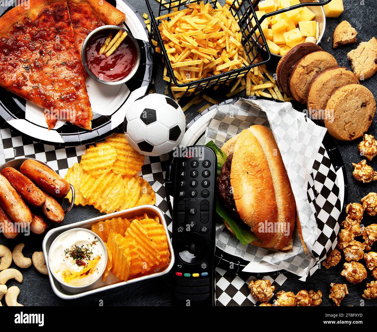 Saturated fats. Football time. TV remote control and snacks - chips ...