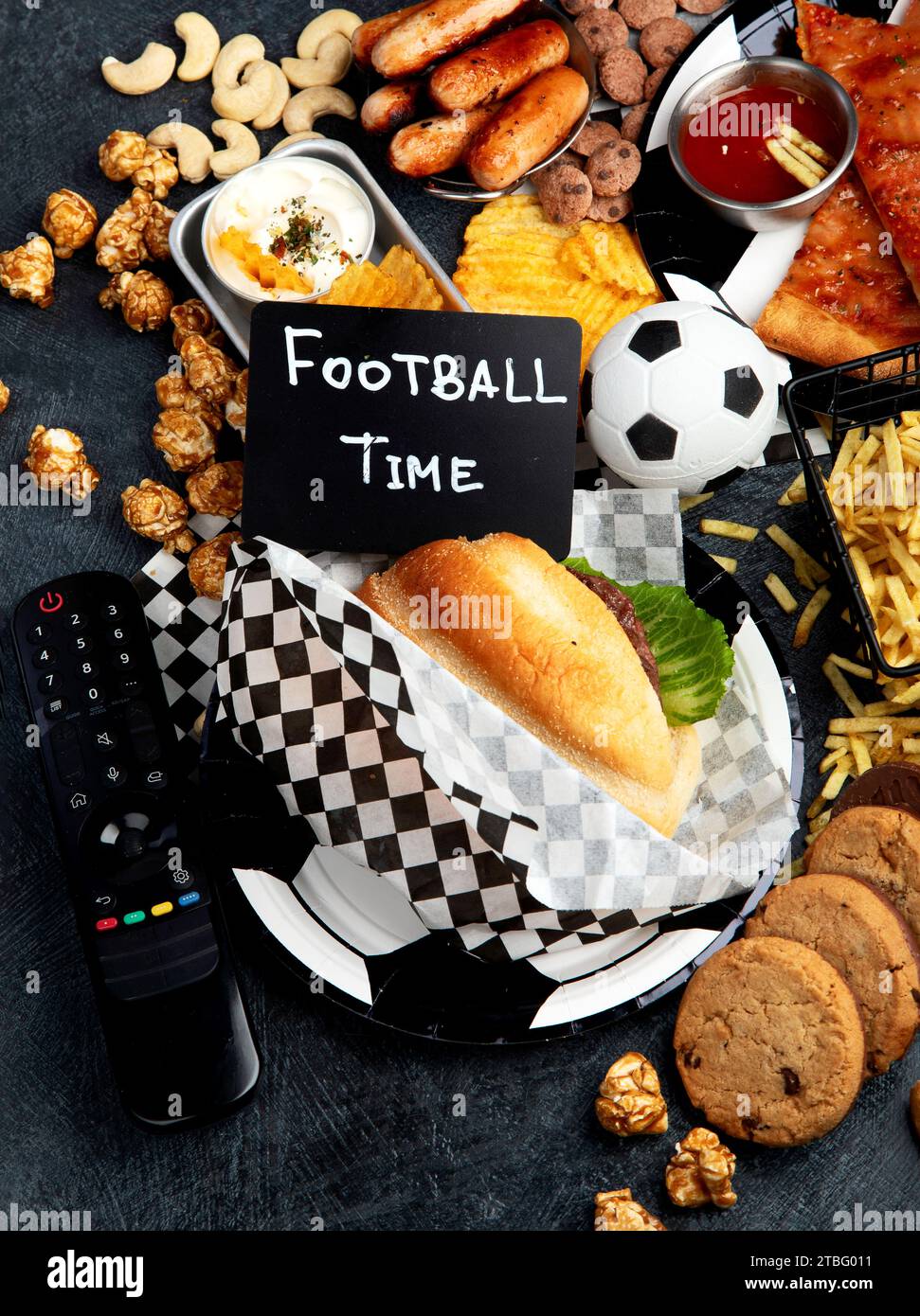 Saturated fats. Football time. TV remote control and snacks - chips ...