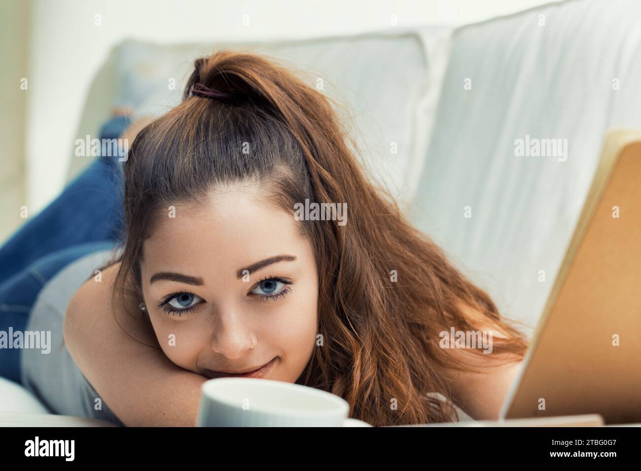 Resting her head on her arms, she offers a smile full of charm, a break ...