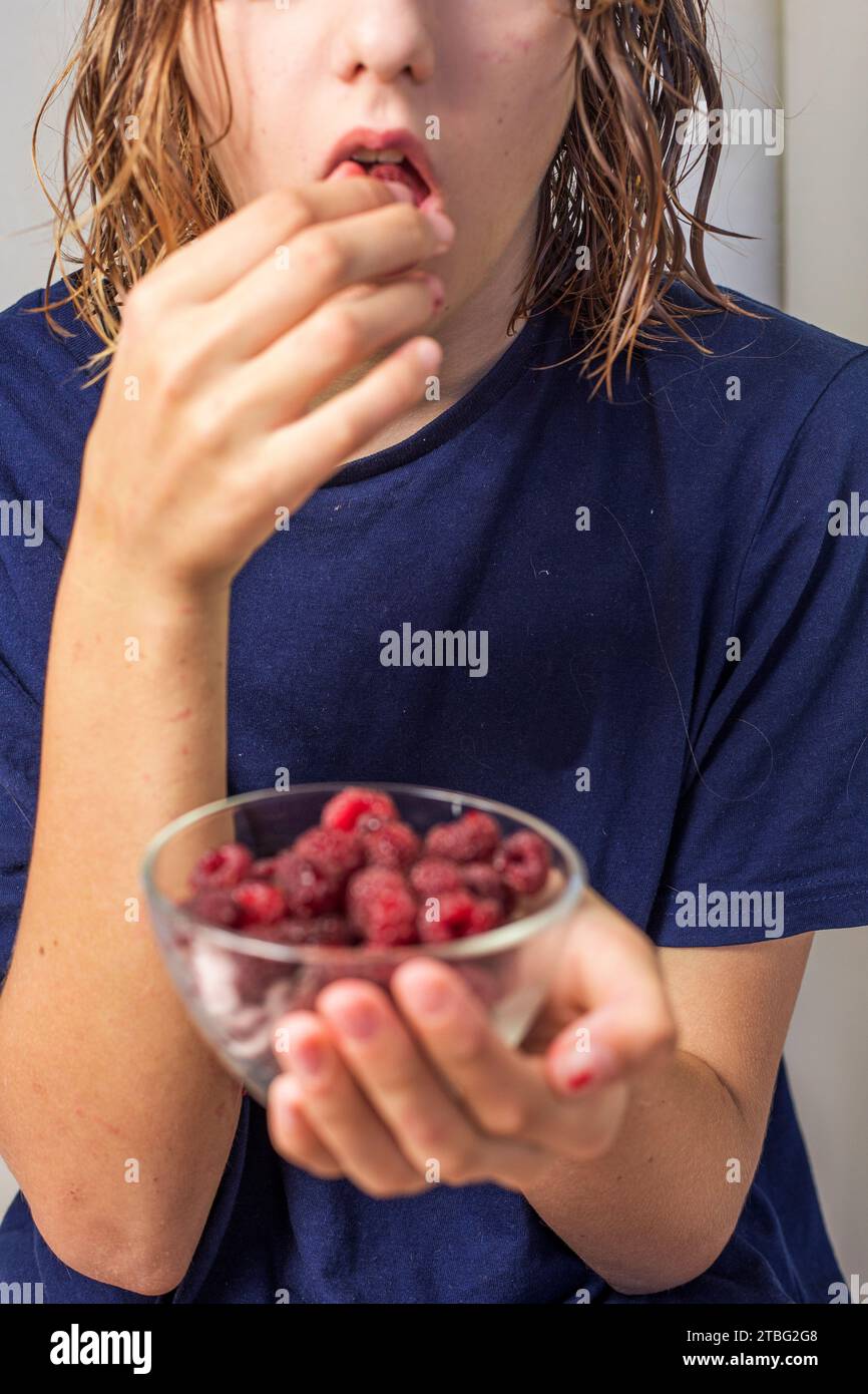 happy teenage girl eats red raspberries Stock Photo - Alamy