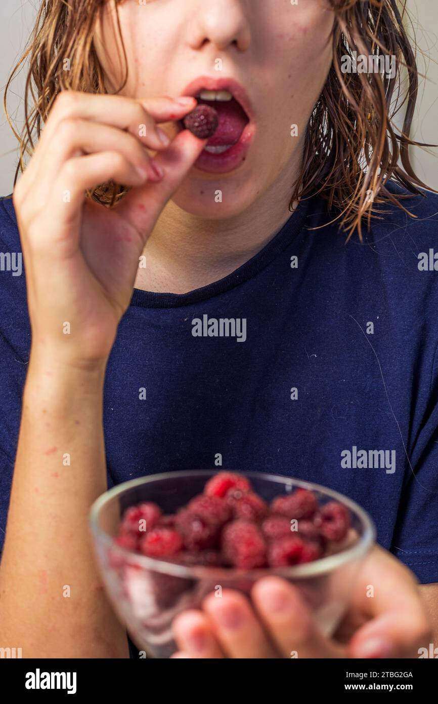 happy teenage girl eats red raspberries Stock Photo - Alamy