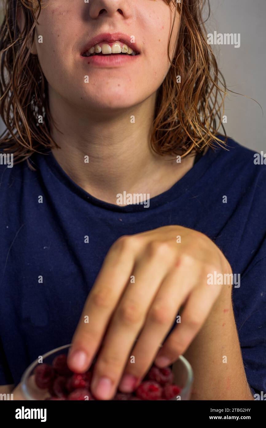 girl eats sour red raspberries Stock Photo - Alamy