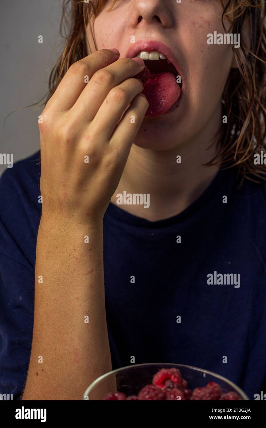 teenage girl eats red raspberries with her mouth wide open Stock Photo ...