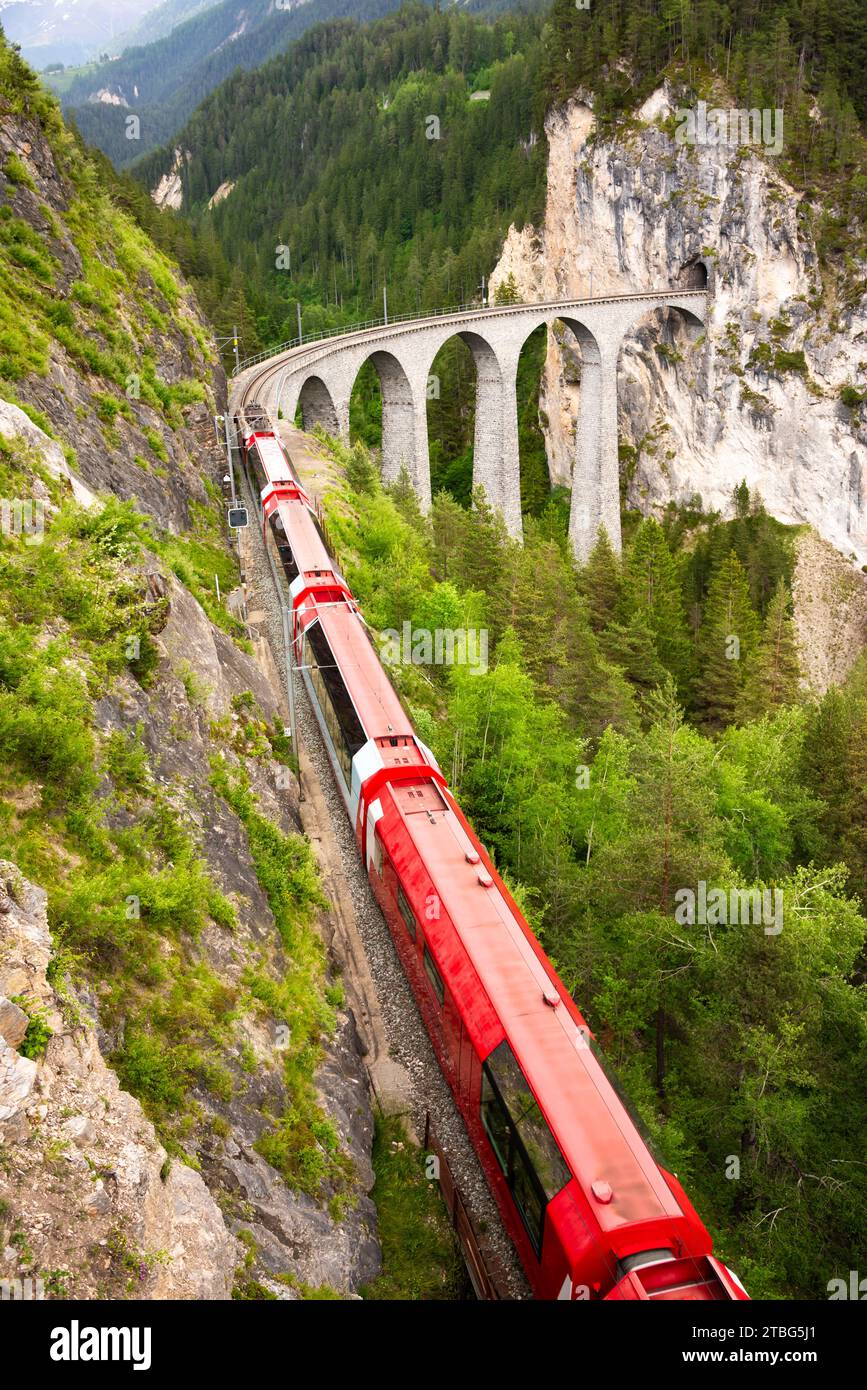 Swiss red train on viaduct in mountain, scenic ride Stock Photo - Alamy