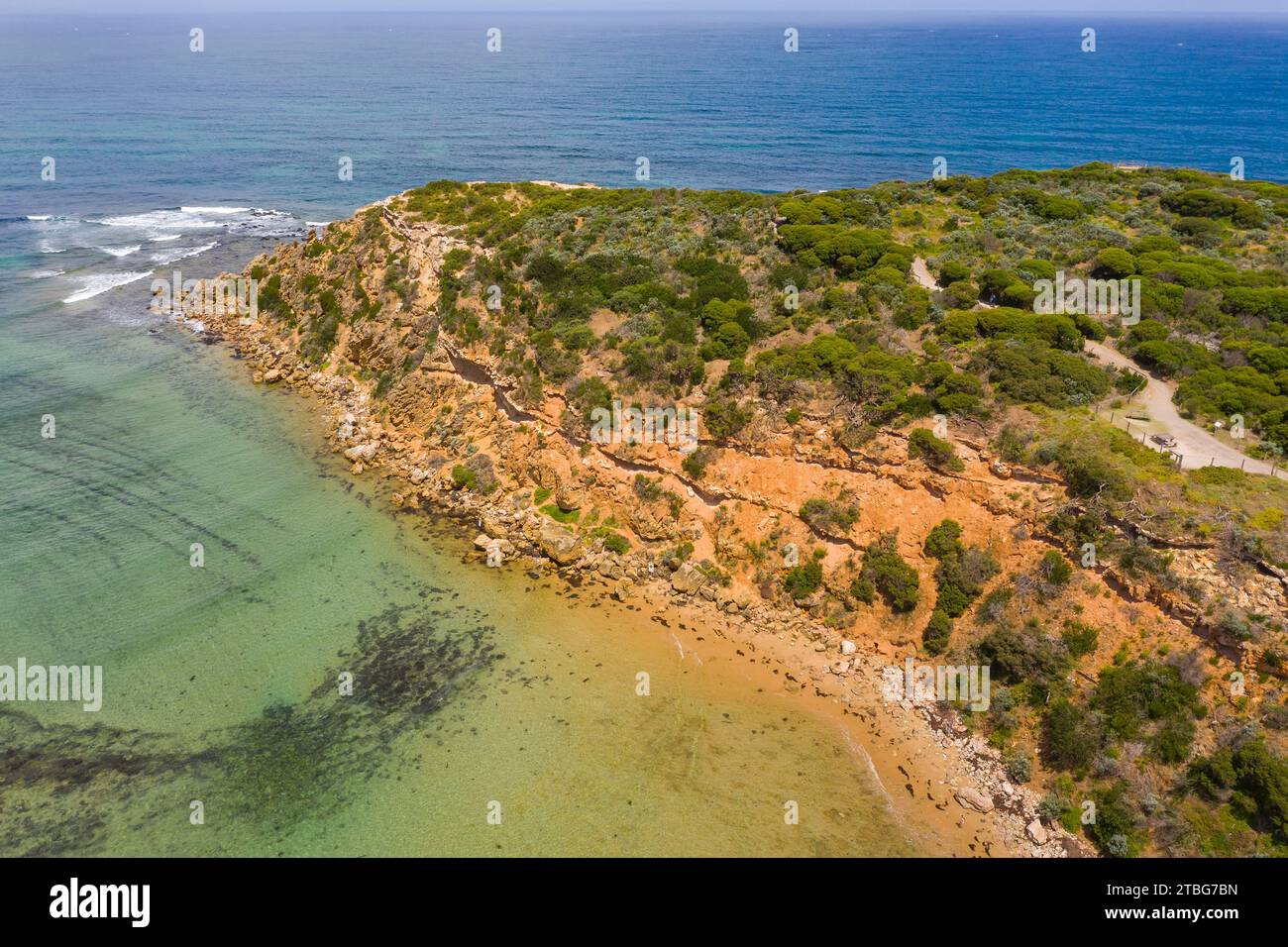 Aerial view of a coastal bluff with a river flowing around it and out ...