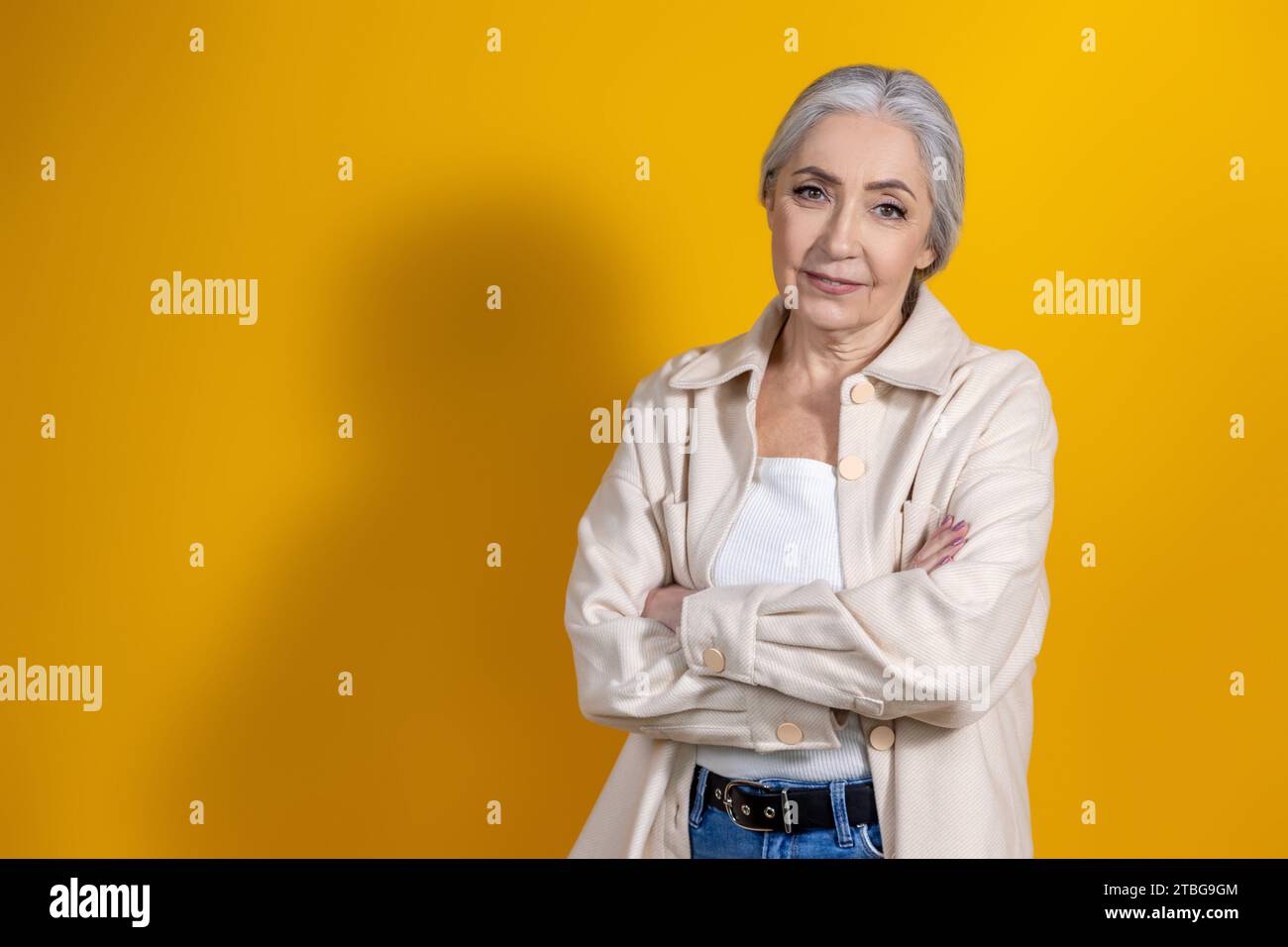 Woman. Good-looking woman in beige standing on yellow background Stock ...