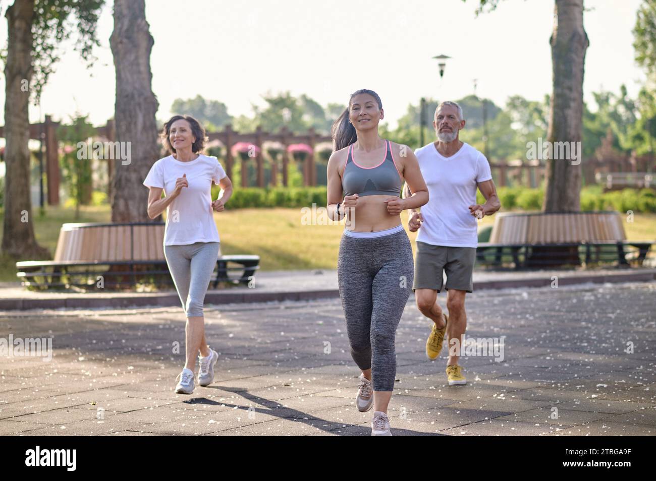 Healthy group of people jogging in park, enjoying friend time at ...