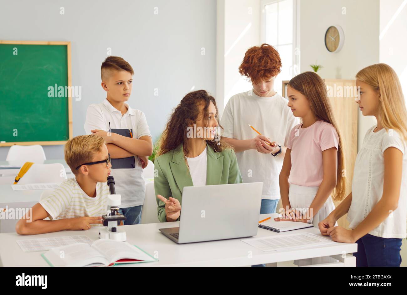 Science teacher is having conversation with group of school children in ...