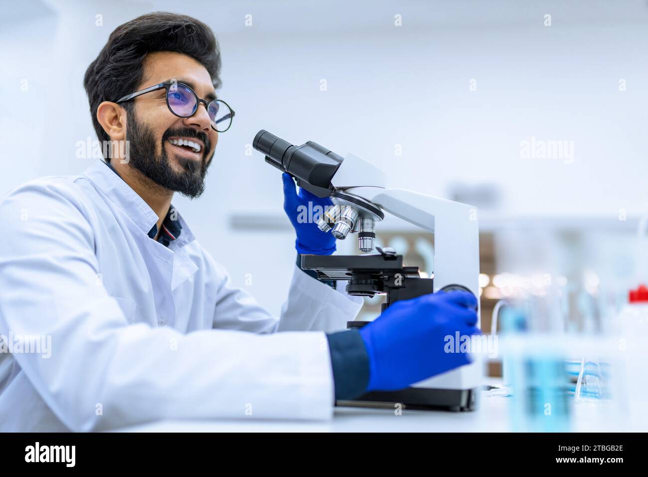 smiling doctor working in modern laboratory research scientist examines ...