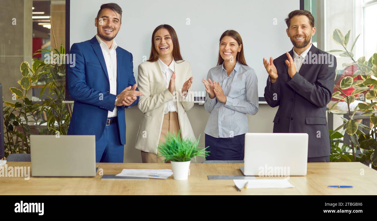 Team of happy people clapping hands after successful presentation at ...