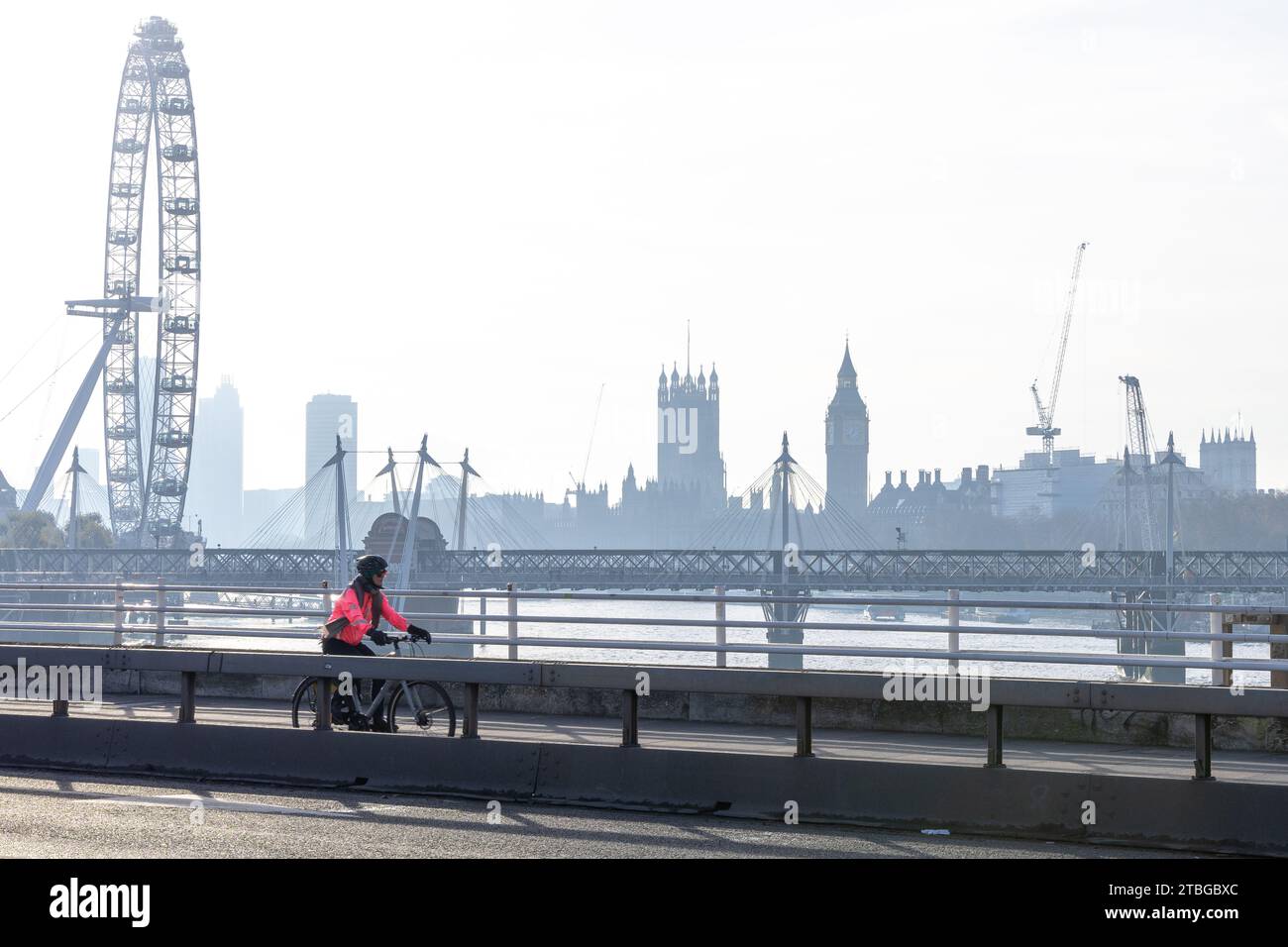 A person on a bicycle wearing a brightly coloured jacket rides over ...