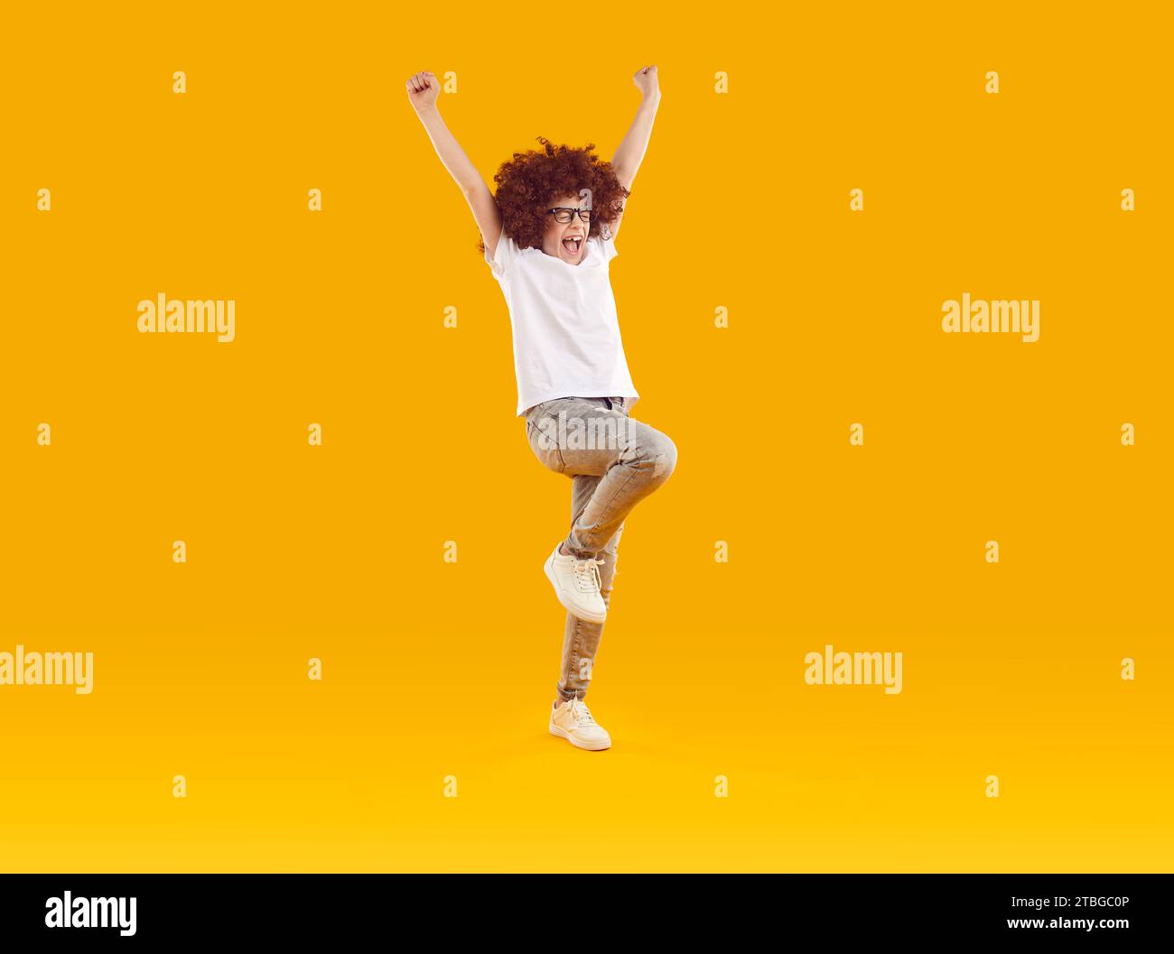 Preteen smiling boy happily jumping with his hands raised Stock Photo ...