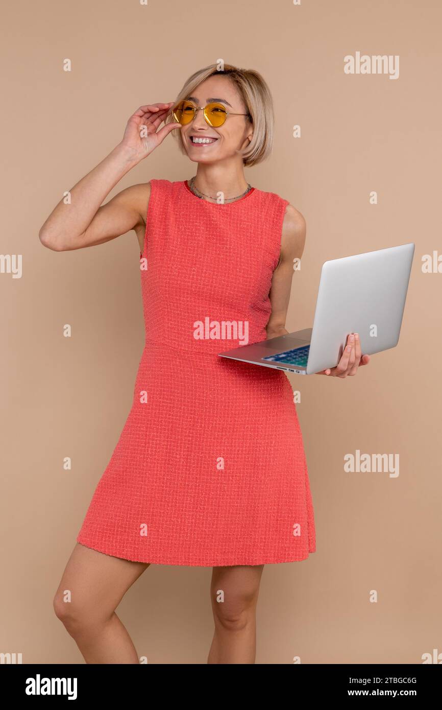 Remote work. Beautiful woman in dress and sunglasses working on ...