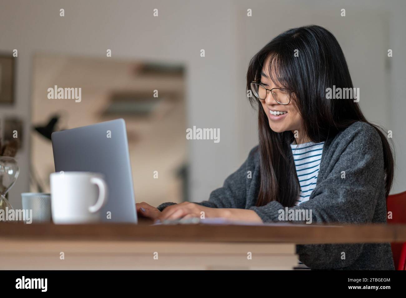 Work from home. Long-haired asian young woman working in her home ...