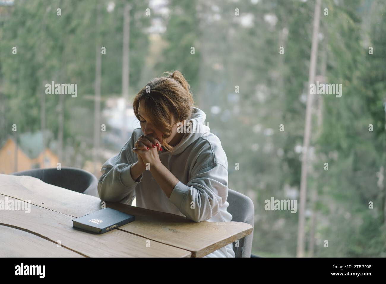 A Woman is praying near the panoramic window Stock Photo - Alamy