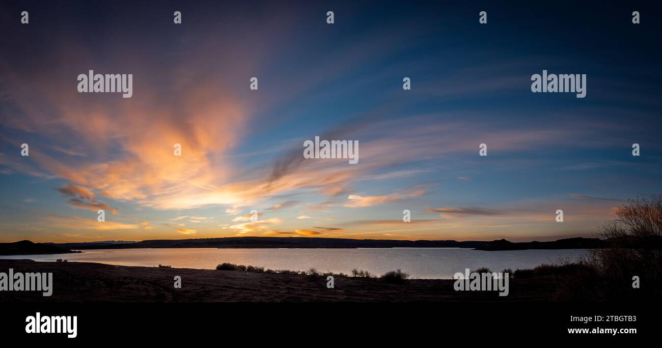 A stunning sunset is visible over a lake, with the sky's reflection ...